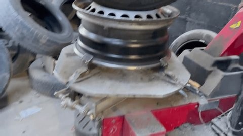 clip-3977222307-mechanic-using-tire-changing-machine-remove-tire-rim