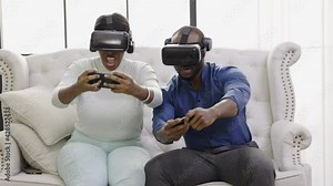 Happy African American family couple Wear virtual reality glasses Play games at home with fun. Use game controller to play Pleasantly. Technology Multimedia and entertainment concept.