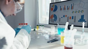 A dedicated scientist in a white lab coat is analyzing samples and complex data on a hightech screen, highlighting advancements in medical sciences, particularly in innovative vaccine development