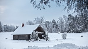 Time lapse shot of wooden house in nature covered in snow after snowstorm at night - Sunrise behind cloudscape at sky - Person snow shoveling path | Premium Stock Video Footage