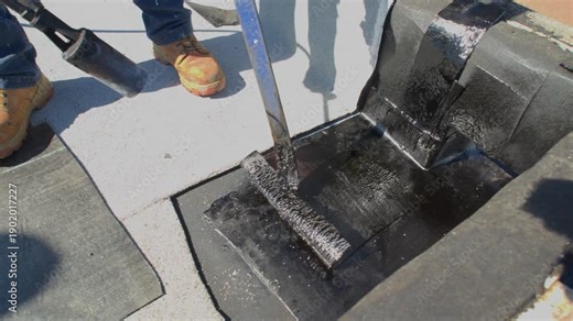 Roofer applying granulated APP Torch Down
