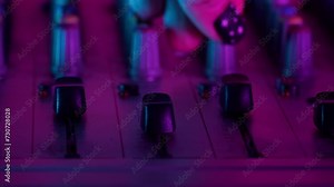 Hands of a DJ man working with a DJ mixer close-up. Professional audio mixer with manual settings, knobs and equalizer, music table for home studio. DJ