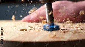 Slow motion of a drill bit drilling into the wood. wood shavings flying in different directions. Close up. forstner drill bit
