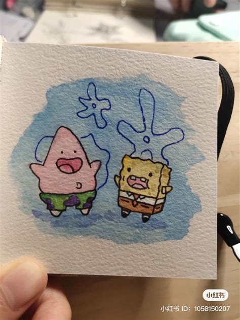 Someone Holding Up A Card With An Image Of Two Cartoon Characters On It