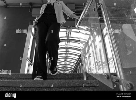 Woman Walking Down The Stairs Holding Onto The Railing A Woman Walks Along An Overpass Girl