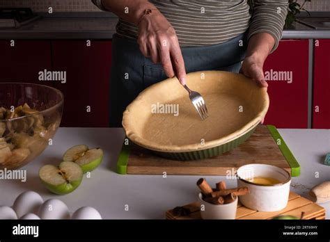 Frau Benutzte Gabel Um Die Löcher über Den Teig Auf Den Tisch In Der Küche Zu Stecken Bevor
