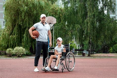 Dad Plays With His Disabled Son On The Sports Ground Concept Wheelchair Disabled Person
