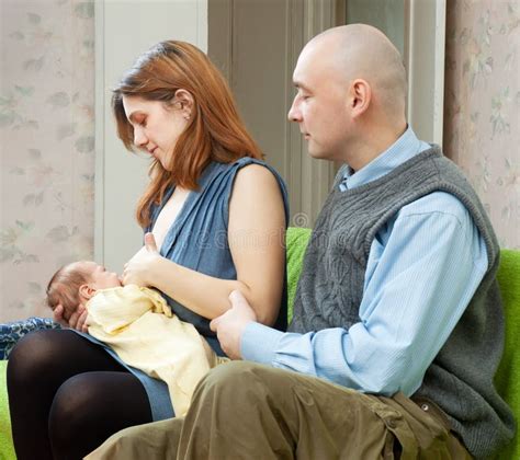 Father Looks At The Baby Sucking Breast Of Mother Stock Photo Image