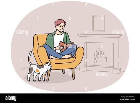 Happy Young Man Sit In Chair At Home Near Fireplace Reading Book Smiling Guy Relax In Armchair