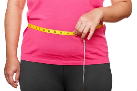 흰색 배경에 고립 된 그녀의 위를 측정하는 뚱뚱한 여자 과체중 비만 프리미엄 사진