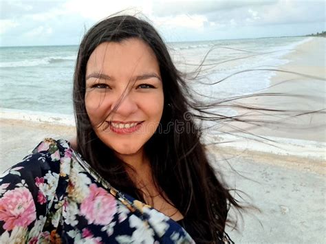 Single Latin Adult Woman Enjoys Her Vacation On The Beach With Calm And Relaxation Takes A