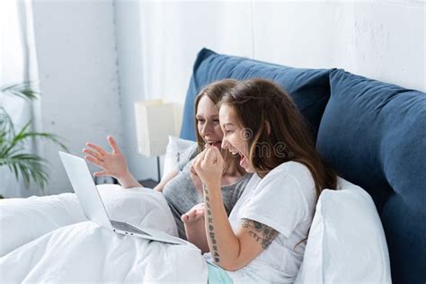 Two Smiling Excited Lesbians Using Laptop In Bed In Morning Stock Image Image Of Girls Love