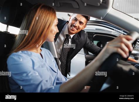 Femme Heureuse Propriétaire Dune Voiture Neuve Assise Sur Le Siège Du Conducteur Photo Stock
