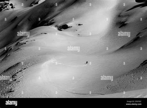 Top View Of Silhouette Unrecognizable Person Riding Snowboard On Snow Covered Landscape During