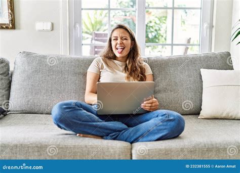 Schöne Junge Brunette Frau Sitzend Auf Dem Sofa Mit Computer Laptop Zu Hause Klebrig Zunge Mit