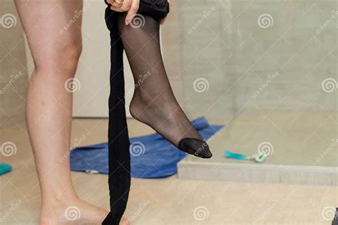 A Close Up Portrait Of A Woman Sensually Pulling Up Sheer Black Nylon Pantyhose With A
