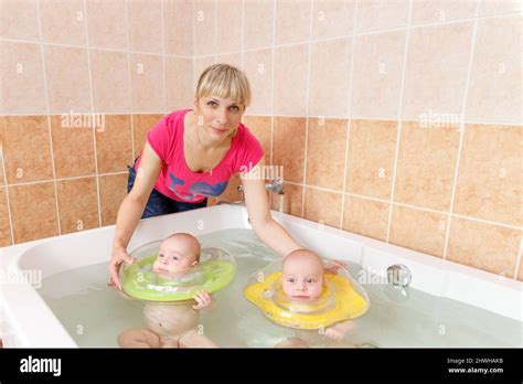 Newborn Twins Swimming In The Bath Or Bathtub Mother Help Them Swim Mom Teaches Them To Swim