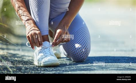 Gearing Up To Tackle A Tough Path Closeup Shot Of An Unrecognisable Woman Tying Her Shoelaces