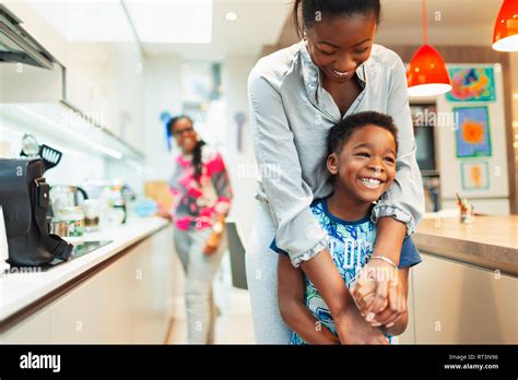 Affectionate Mother And Son Hugging In Kitchen Stock Photo Alamy