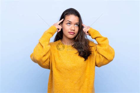 穿着毛衣的哥伦比亚年轻女孩在孤立的蓝背景上充高清图片下载 正版图片504431484 摄图网