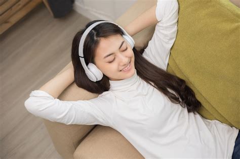 Premium Photo Relaxing Time On Sofa Beautiful Young Asian Woman Lay Down On Sofa And Listening