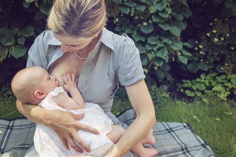Mother Breastfeeding Baby Girl Outdoors In Summer Nature Motto