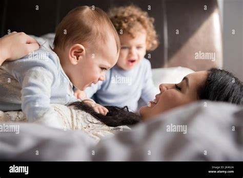 Caucasian Mother Laying On Bed Playing With Sons Stock Photo Alamy
