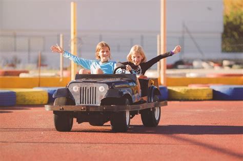 Premium Photo Portrait Of Girl With Sister Riding Toy Car