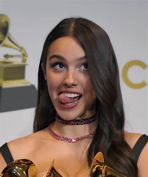 A Woman Holding Two Golden Trophies In Her Hands And Making A Funny