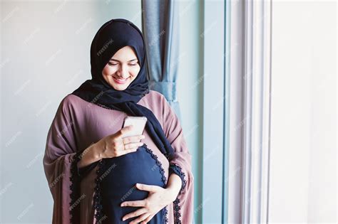 Premium Photo Young Pregnant Arab Woman In Hijab Using Her Mobile Phone To Send Message