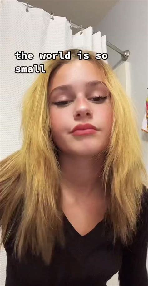 A Woman With Long Blonde Hair Is Looking At The Camera