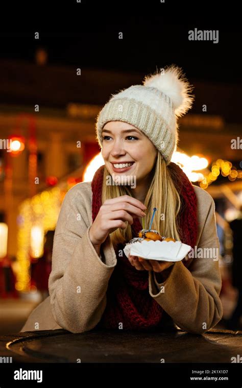 Portrait Of Happy Young Woman Eating Donuts On The Christmas Market Holiday Fun People Concept
