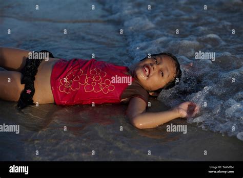 Linda chica asiática preadolescentes tendido en el agua chapoteando en