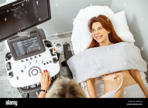 Woman Examining Her Pelvic Organs With Ultrasound Sensor Or Diagnosing Early Pregnancy At The