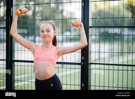 A Young Sympathetic Girl Of Slender Body Dressed In A Form Of Sport Performs Outdoor