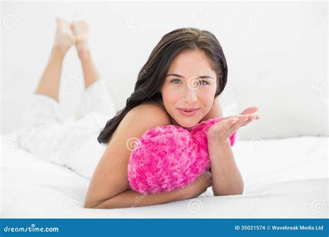 La Donna Con Cuore Ha Modellato Il Bacio Di Salto Del Cuscino A Letto Fotografia Stock