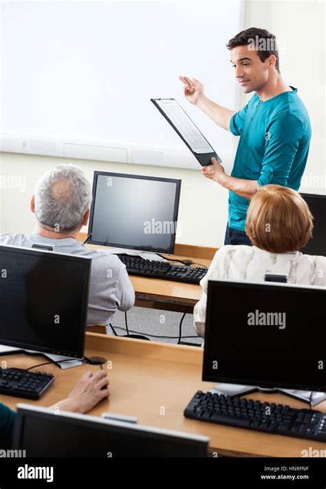 profesor dando clases a los alumnos de los cursos superiores en el laboratorio de computación