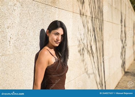 South American Woman Young And Beautiful Brunette Wearing A Brown Dress Posing Leaning