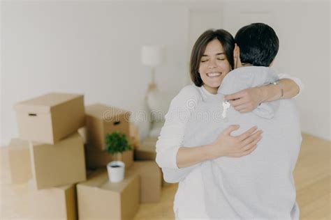 Happy Brunette Woman Embraces Husband With Love Being In Good Mood Smiles Positively Husband