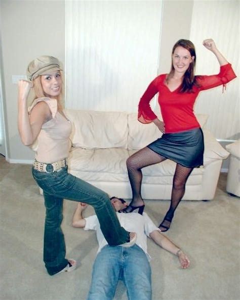 Two Women Are Posing For The Camera In Front Of A Man Laying On The Floor