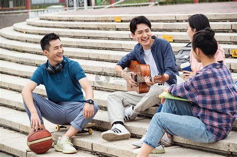 同学课外活动彩色图片年轻的大学生坐在台阶上闲聊高清图片下载 正版图片501902821 摄图网