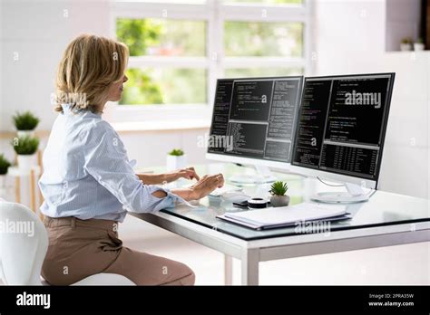 Programmer Woman Coding On Multiple Computer Screens Stock Photo Alamy