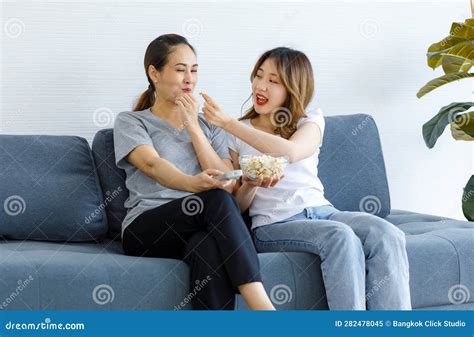 Millennial Asian Young Happy Cheerful Female Lesbian Lgbtq Lover Couple Sitting On Cozy Sofa