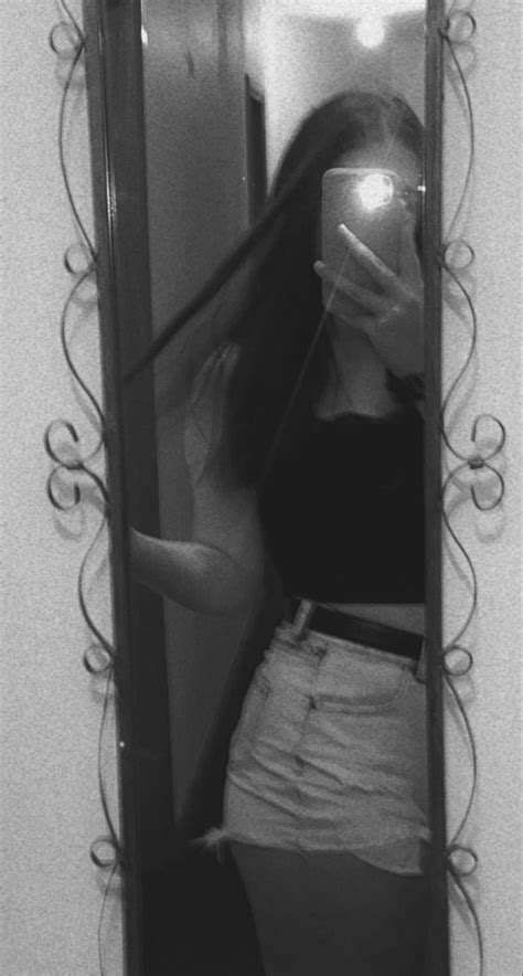 A Woman Taking A Selfie In Front Of A Mirror