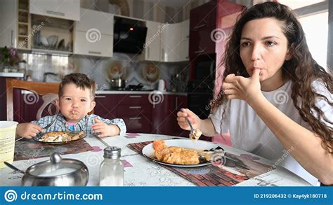 Madre Joven Comiendo En La Cocina Sentada A La Mesa Foto De Archivo Imagen De Bebida Gente