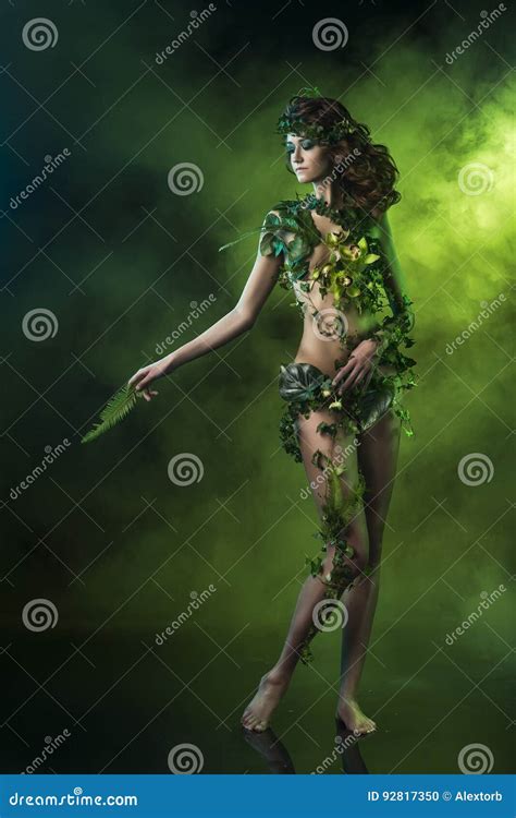 Naked Girl In Clothes From Leaves On The Background Of Green Fog Stock
