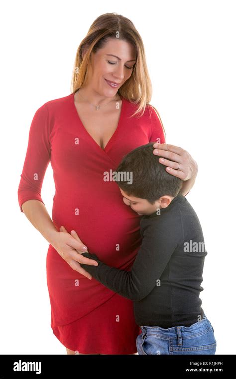 Portrait Of Beautiful Pregnant Mother With His Older Son Kissing Her